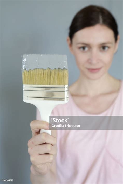 페인트 브러시를 들고 있는 젊은 여성의 초상화 흰 벽에 회색 페인트로 칠한 여성 Diy에 대한 스톡 사진 및 기타 이미지 Diy 가정 생활 개선 Istock
