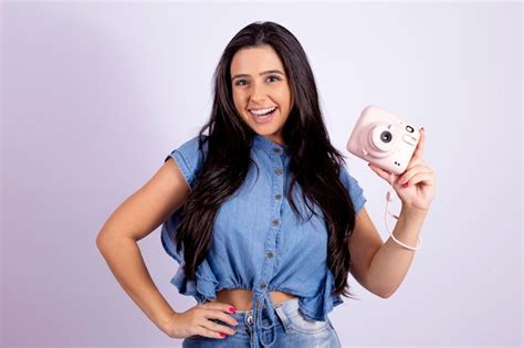 Premium Photo Attractive Girl Holding A Polaroid Camera Smiling At The Viewer