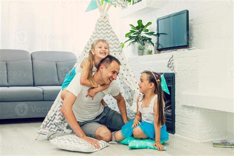 Papá Feliz Cargando A Dos Niñas Lindas En La Espalda Dando A Los Niños