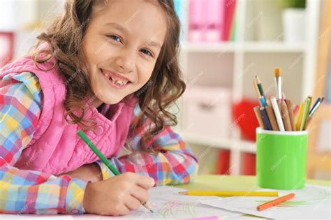 Premium Photo Portrait Of Girl Sitting At Table And Drawing