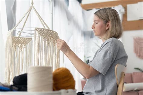 Woman Making Macrame Lampshade Using White Cord To Tie The Strings