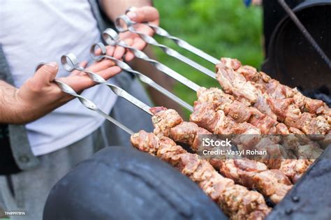 수석 밥 솥의 손이 열려있는 불에 집에서 바베 큐 굽고 고기의 육즙 조각과 금속 스틱을 기울이기 여름 자연 소풍 가리기에 대한 스톡 사진 및 기타 이미지 Istock