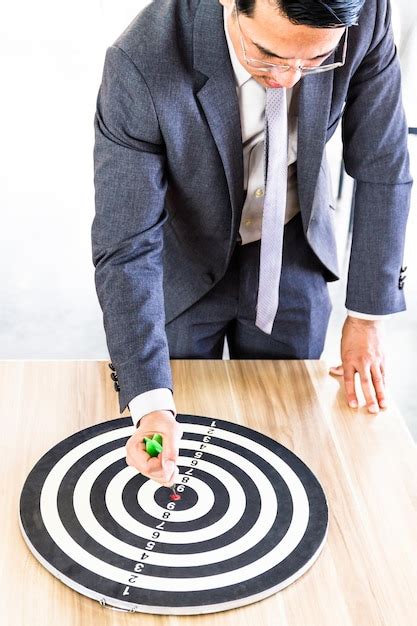 Premium Photo Businessman Putting A Dart Hit On The Target Board