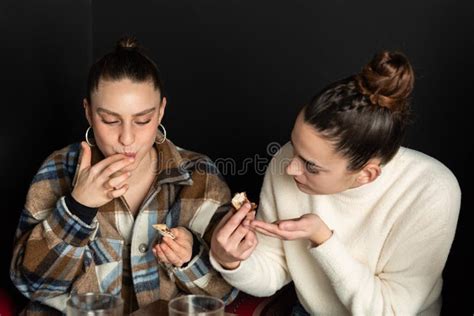 Girls Lick Their Fingers While Eating Chocolate Cream Desserts Stock
