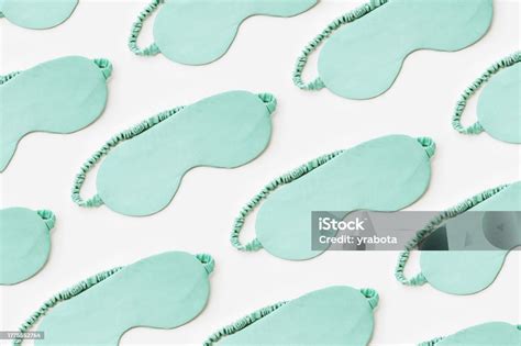 하얀 빛 배경에 실크 수면 마스크의 최소한의 패턴 최고의 잠자는 사람 여행 편안한 휴식을 위한 민트 컬러 패션 아이 마스크 밤 시간과 수면 개념 평평한 누워 구성 개념에