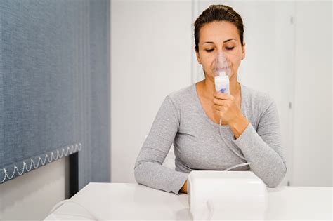 가정이나 병원 독감 천식 기관지염 바이러스 치유에서 에어로졸 흡입 의학 치료를하고 증기 흡입기 분무기를 사용하는 성인 여성의 초상화 가정 생활에 대한 스톡 사진 및 기타