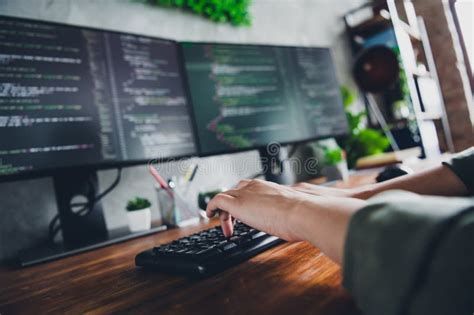 Young Software Developer At A Dual Monitor Computer Coding In A Modern Workspace For Programming