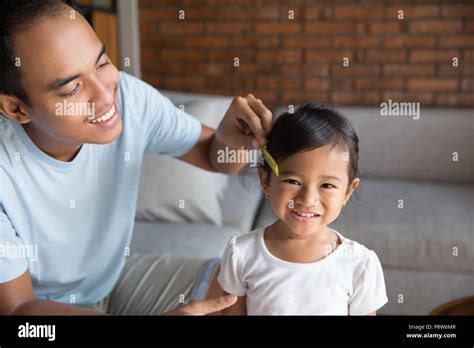 Dad Help Her Daughter To Comb Her Hair At Home Stock Photo Alamy