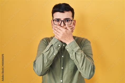 Non Binary Person Standing Over Yellow Background Shocked Covering