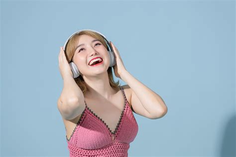 행복한 아시아 밀레니엄 세대 소녀의 스튜디오 샷은 스마트 폰과 헤드폰을 사용하여 기쁜 마음으로 멀리 바라 봅니다 30 34세에 대한 스톡 사진 및 기타 이미지 Istock