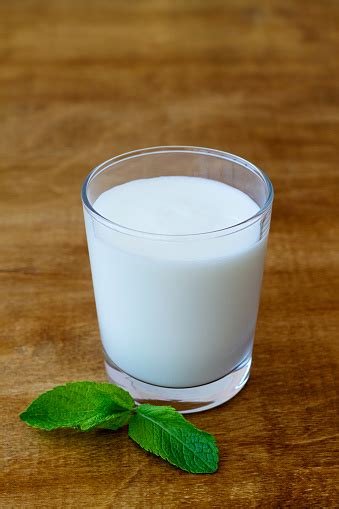 나무 배경에 유리에 녹색 민트와 Lassi 음료 의 유리 프로바이오틱 콜드 발효 유제품 음료 건강하고 발효 된 제품 개념 공간을 복사합니다 케피르 우유 또는 요구르트 와