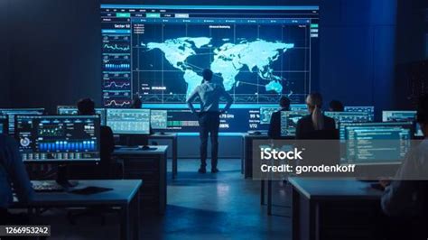 프로젝트 관리자는 신경망이 있는 큰 화면 옆에 서 있습니다 전문 컴퓨터 데이터 과학 엔지니어 팀이 어두운 시스템 제어 및