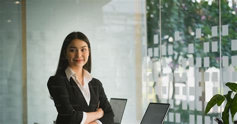 양복을 입은 자신감 넘치는 사업가가 팔짱을 끼고 앉아 현대 사무실에서 카메라를 향해 웃고 있다 사진 Unsplash의 기업가 이미지