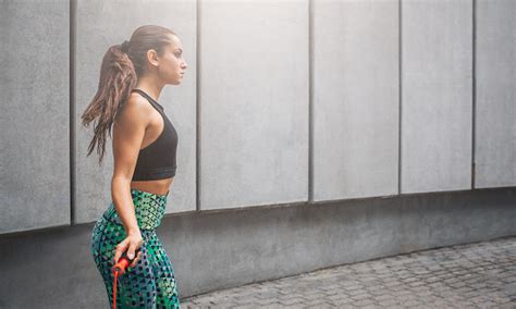 점프 하 고 그 오렌지 밧줄을 사용 하 여 잘 구축 하 고 강한 여자의 그림 그녀는 곧장 앞으로 보인다 모델 좋은 모양입니다 그녀는 스포츠 의류를 착용 가냘픈에 대한 스톡