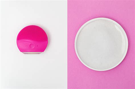 스킨 케어 피부를 청소하고 분홍색과 흰색 배경에 공기 거품을 정화얼굴 브러시와 평면 평신도 구성 세탁용 폼 맨 위 보기 개념에