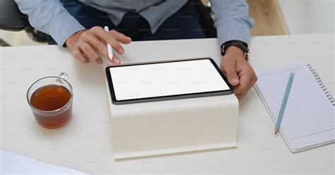 스타일러스 펜을 들고 흰색 사무실 책상에서 디지털 태블릿으로 작업하는 사업가의 자른 사진 사진 Unsplash의 기술 이미지