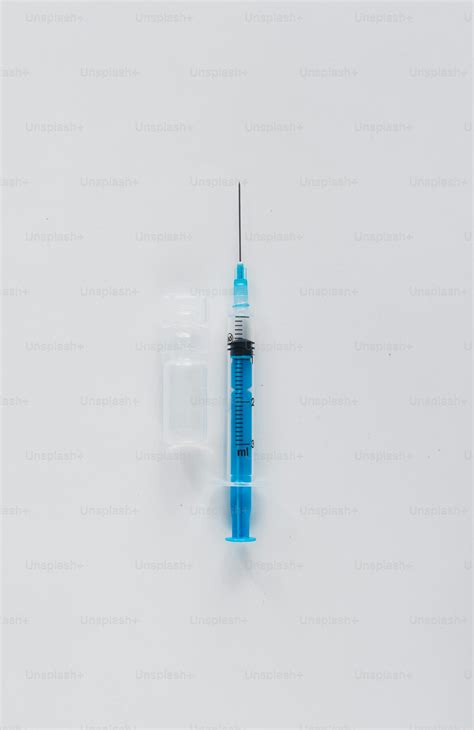 바늘이 튀어 나와있는 작은 파란색 튜브 사진 Unsplash의 의료 이미지