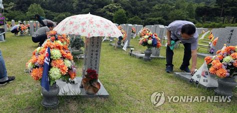 아들 너도 덥지 묘비에 양산 씌워준 어머니