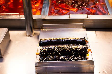 현지 호커 노점 길거리 음식 바자회에서 한국 전통 미식 요리 오뎅떡볶이와 어묵 김밥 또는 김밥을 곁들인 여행자를 위해 방문 방문 부산이나 부산에서 음료를 먹고 한국 거리에
