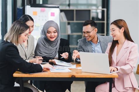 Diverse Business Team Analyzing Data And Discussing Strategies During