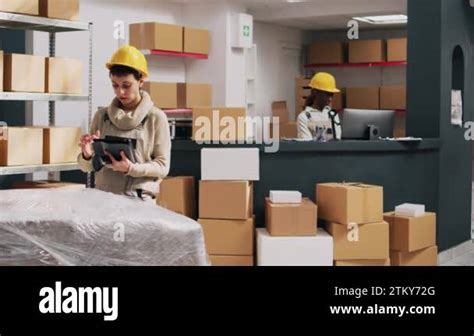 Male Worker Giving Package Of Goods To Supervisor Helping To Scan