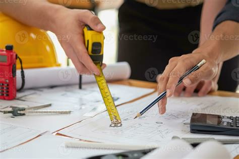 Asian Engineers Brainstorm And Measure To Document Cost Estimates And