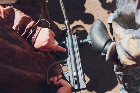 위장복을 입은 남자는 페인트볼 총을 들고 페인트볼 구역에 서서 똑바로 쳐다보고 있다 겨냥에 대한 스톡 사진 및 기타 이미지 겨냥 군사 긍정적인 감정 표현 Istock