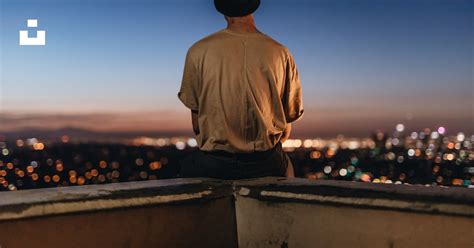 Person Sitting On Rooftop Ledge During Nighttime Photo Free Sledge Image On Unsplash