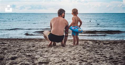 낮 동안 해변에서 파란색 플라스틱 양동이를 들고 있는 검은 반바지를 입은 남자 사진 Unsplash의 무료 바다 이미지