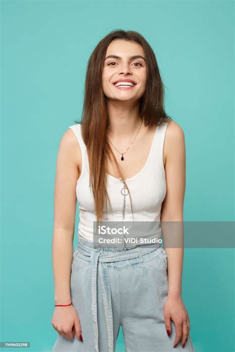 스튜디오에서 파란색 청록색 벽 배경에 고립 된 빛 캐주얼 옷을 찾고 쾌활 한 젊은 여자 웃는의 초상화 사람들은 진심으로 감정 라이프 스타일 개념입니다 복사 공간을 모의