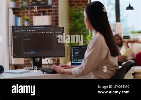 Asian Female Developer Coding Cloud Computing Applications On Pc In A Modern Tech Workspace