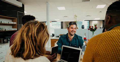 동료들이 고객과의 비즈니스 미팅 전에 사무실 로비에서 점심 시간에 채팅하는 동안 노트북에 타이핑하는 여성 고품질 사진 사진 Unsplash의 사업 이미지