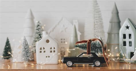 메리 크리스마스와 새해 복 많이 받으세요 축제 크리스마스 장면 미니어처 휴가 마을 흰색 배경에 크리스마스 트리 작은 집 눈 덮인 나무가 있는 세련된 자동차