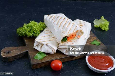 검은 배경에 맛 있는 샤 왈 마 샌드위치 부리토에 구운 닭고기와 채소 채소로 감싼 답니다 파히타 피타 빵 전통적인 중동 전채 요리 건강 한 음식 멕시코 요리를 제공 합니다