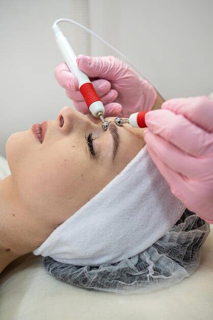 Premium Photo Cosmetologist Doing Microcurrent Treatment Procedure For Her Female Client At