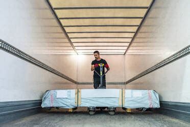 Worker Pushing Pallet Jack Loading In Cargo Container Stock Photo