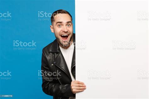 잘생긴 젊은 언 면 한 사람이 파란색 벽 배경 스튜디오 초상화에 고립 된 프로 모션 콘텐츠에 대 한 큰 흰색 빈 빈 광고 판을 개최 합니다 사람들은 진심으로 감정 라이프