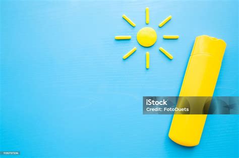 자외선 차단제와 파스텔 파란색 배경에 태양 모양의 노란색 튜브 더운 여름 피부 보호에 관심 일광욕 개념입니다 텍스트 인용 격언 또는 로고에 대 한 빈 장소 평면도 0명에