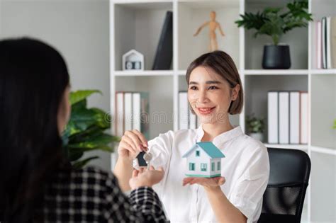 Real Estate Agent Handing Over House Keys To New Homeowner In Modern