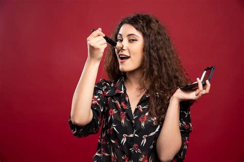 Free Photo Young Woman Tickles Her Nose With Tassel
