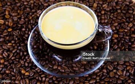 셀 수 없이 많은 볶은 콩 배경에 카페 크레마가 있는 유리 접시에 분리된 투명 커피 컵 가득 찬에 대한 스톡 사진 및 기타