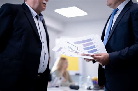 사무실에서 전문적인 회의 중에 차트와 그래프에 대해 논의하는 두 명의 사업가 25 29세에 대한 스톡 사진 및 기타 이미지