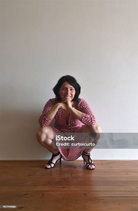 Женщина Сидит На Корточках Перед Стеной Ура — стоковые фотографии и другие картинки 40 49 лет