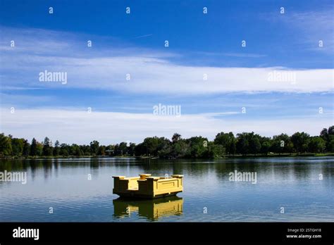 A Floating Yellow Sculpture Structure Floating On A Pond At Denver Botanic Gardens With Dramatic