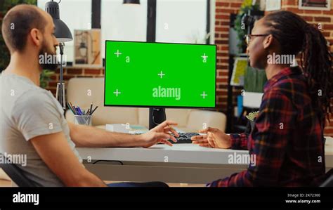 Diverse Team Working On Computer With Greenscreen At Desk Using Monitor To Examine Isolated