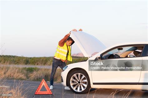 시골의 길가에서 무너진 후 열린 자동차 후드에 기대어 조끼를 입은 청년 차량 고장에 대한 스톡 사진 및 기타 이미지 차량 고장 차 좌초된 Istock