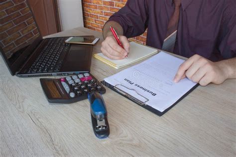 Man Writing Notes From Computer On Wooden Table Man Hand With Pen Calculator And Computer On