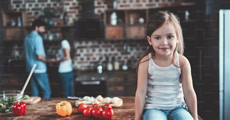 엄마 아빠 딸이 부엌에서 요리하고 있어요 행복한 가족 개념 잘 생긴 남자 매력적인 젊은 여자와 귀여운 딸이 함께 샐러드를 만들고 있습니다 건강한 라이프 스타일
