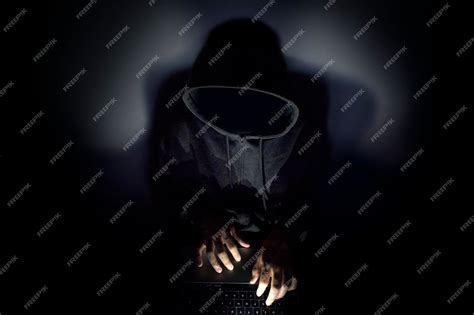 premium photo hacker with hood using computer in darkness