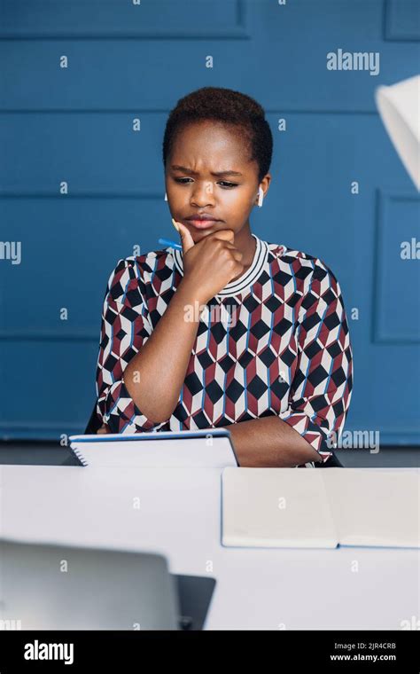 african businesswoman analyzing information while working with application on laptop thinking
